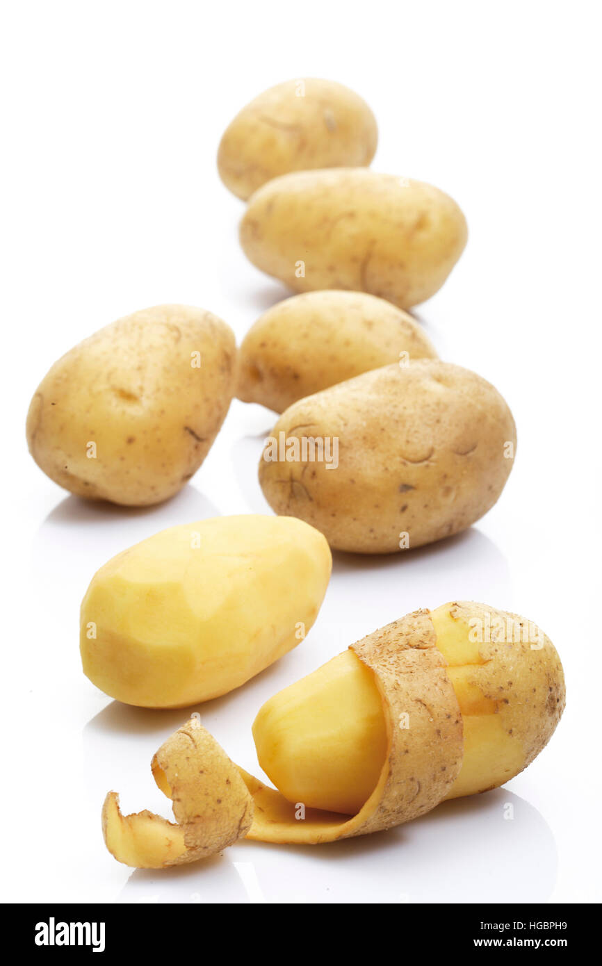 Raw potatoes, peeled and unpeeled Stock Photo - Alamy