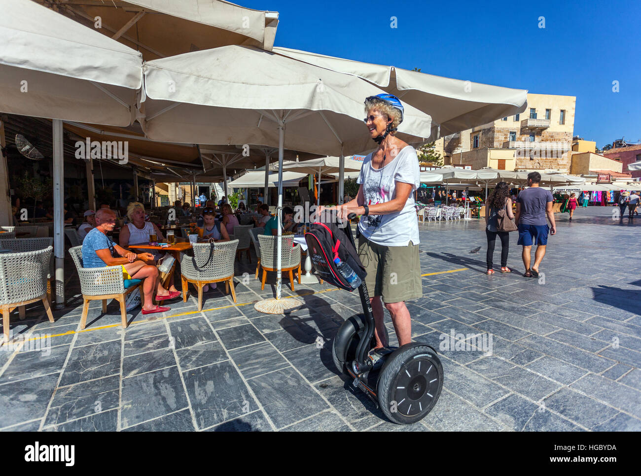 senior tourist, elderly woman in the old Venetian port using segway ...