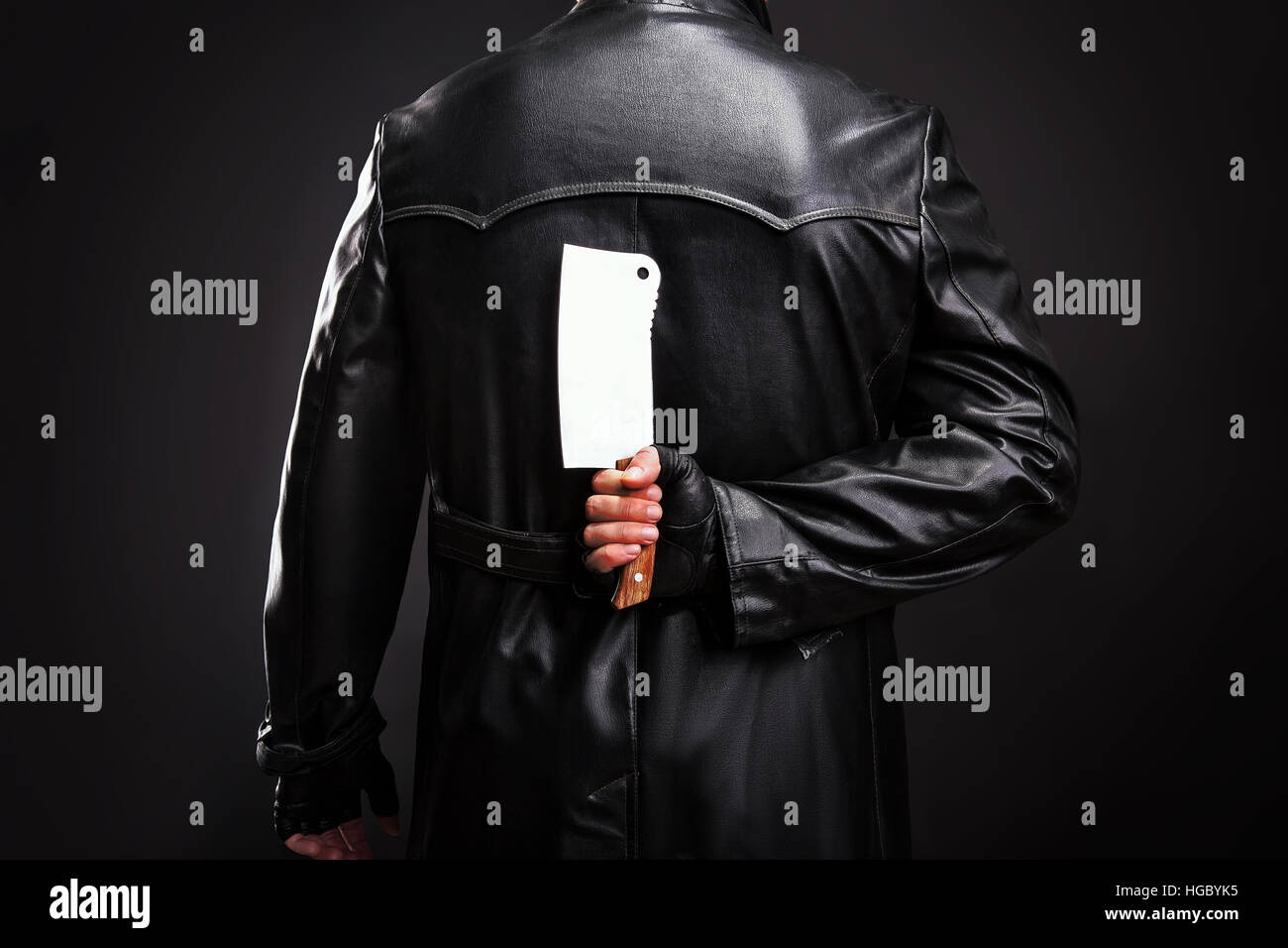 Serial murderer holding meat cleaver behind back Stock Photo - Alamy