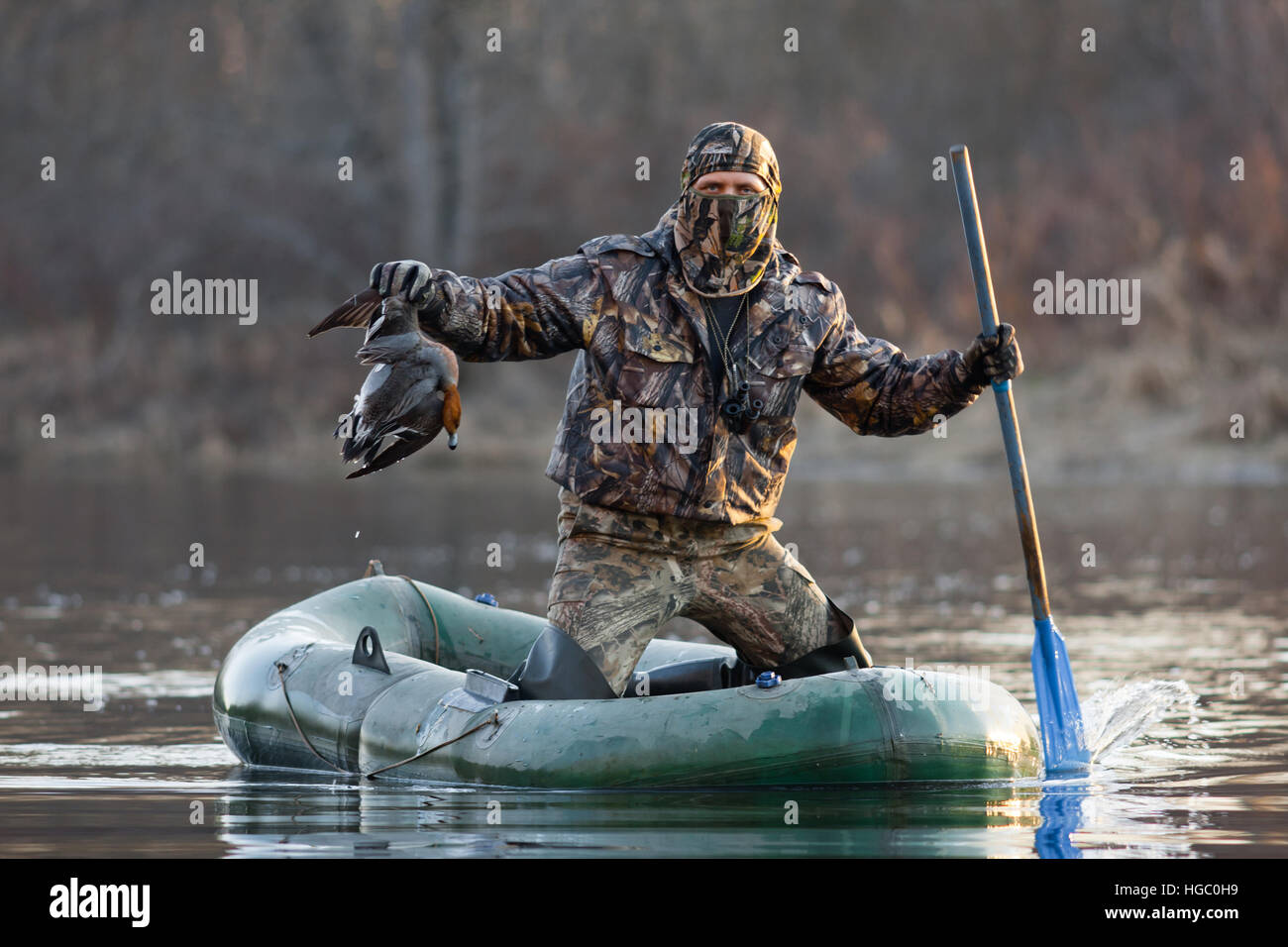 hunter with duck in a boat Stock Photo - Alamy