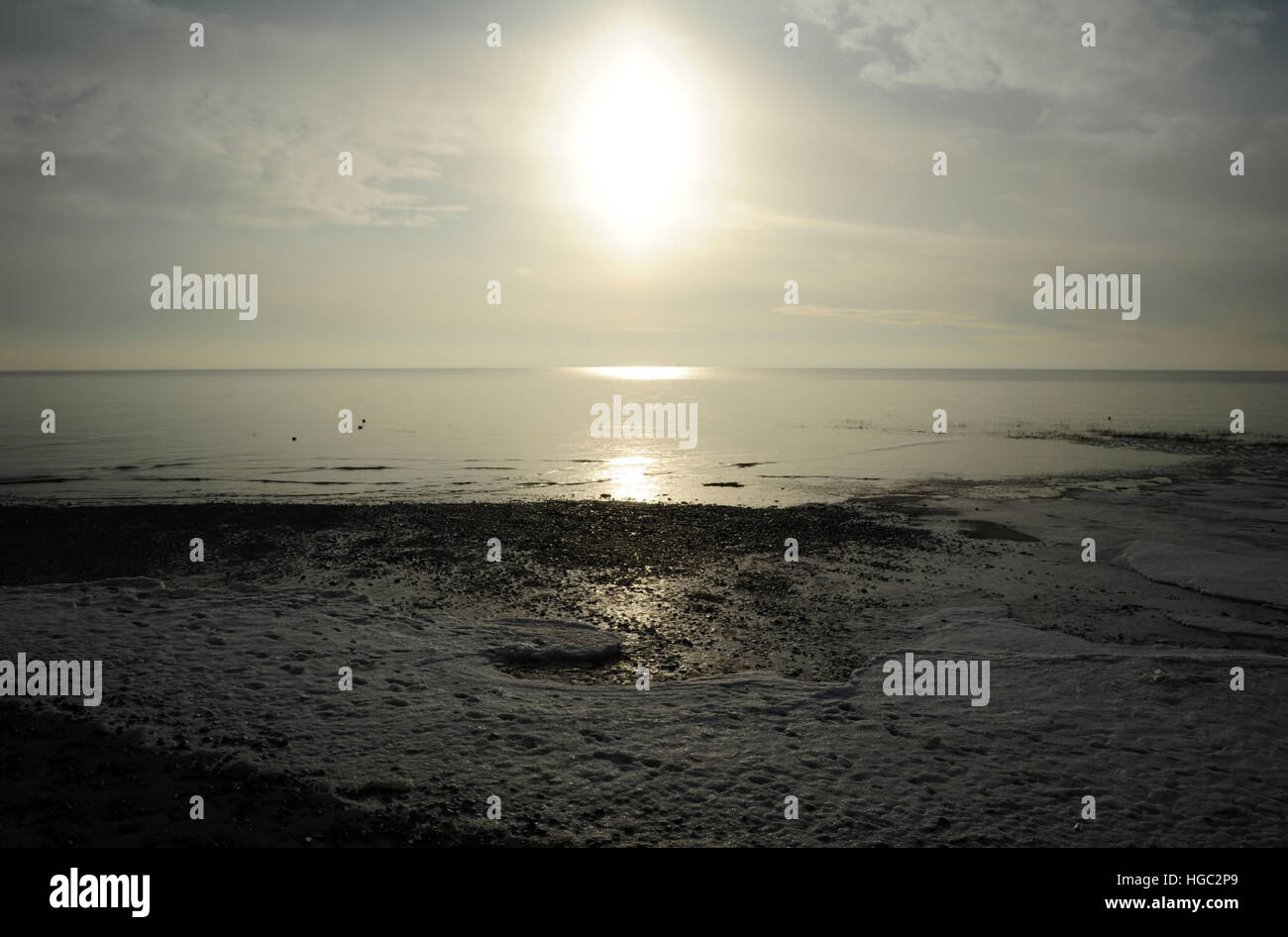 View south across River Ribble Estuary to white sun clouds sky, sea ice ...
