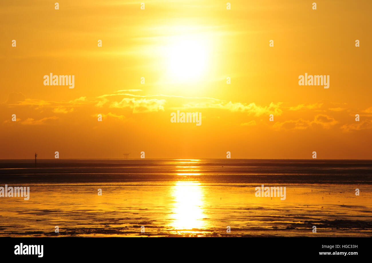 White sun sinking yellow sky and shining on sand beach expanse, looking ...
