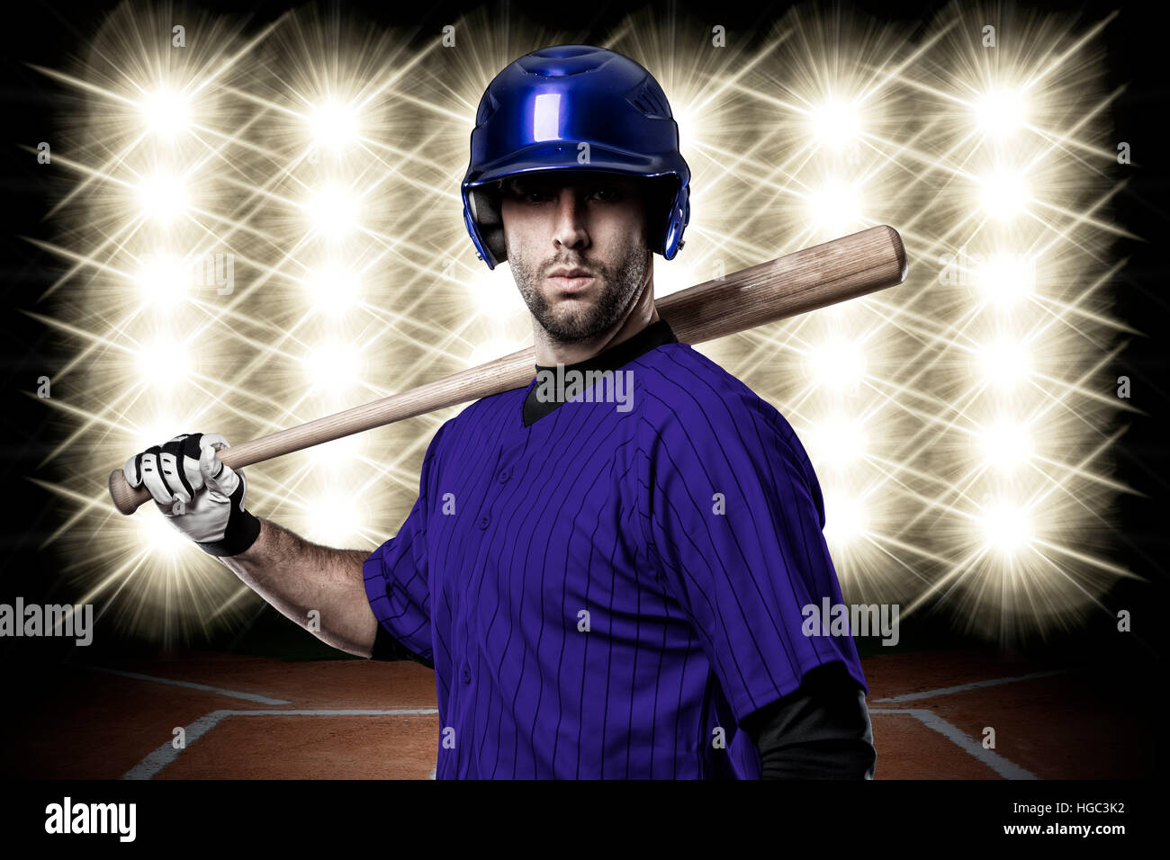 Baseball Player with a blue uniform in front of lights Stock Photo - Alamy