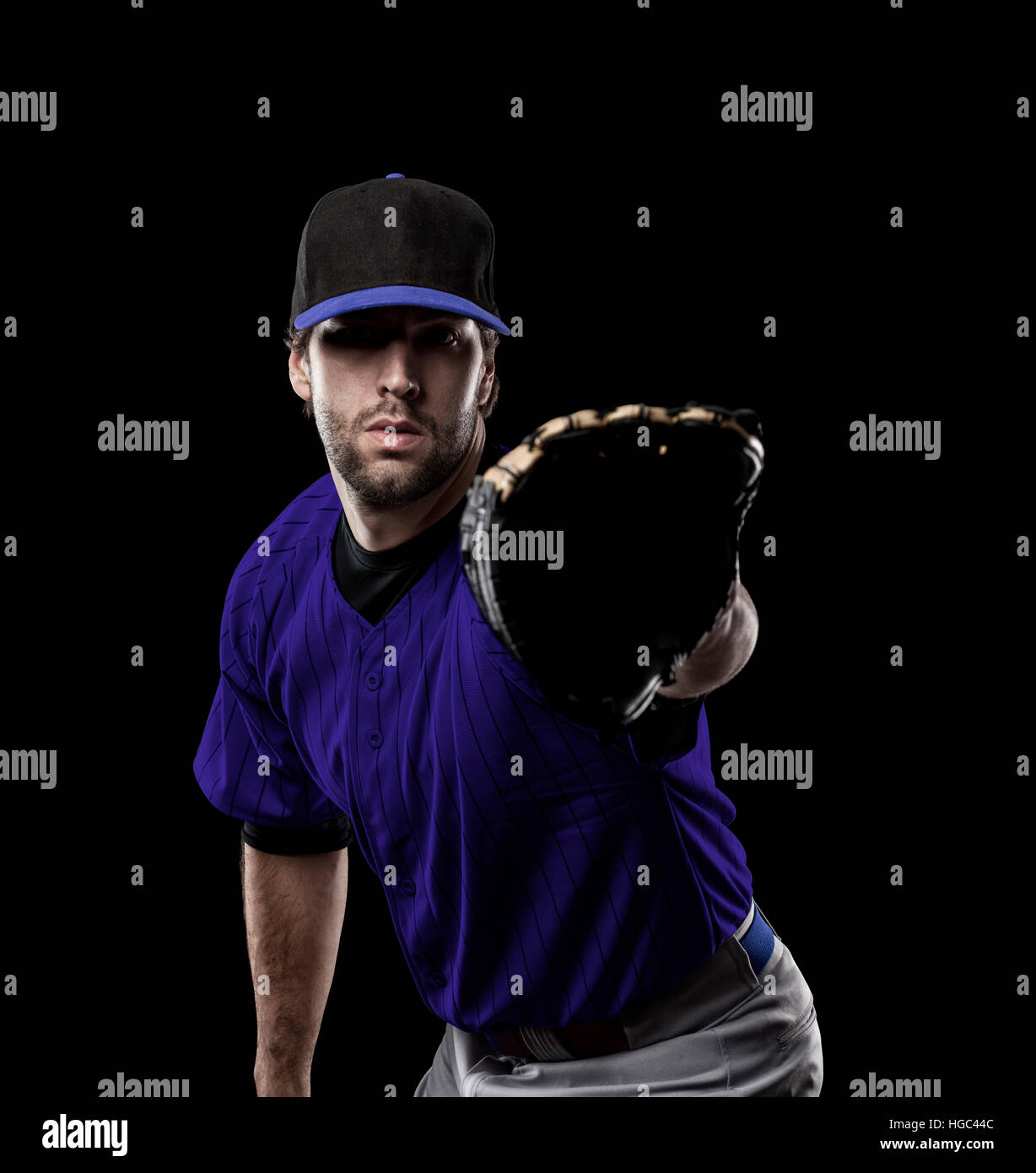 Baseball Player with a blue uniform on a black background Stock Photo ...