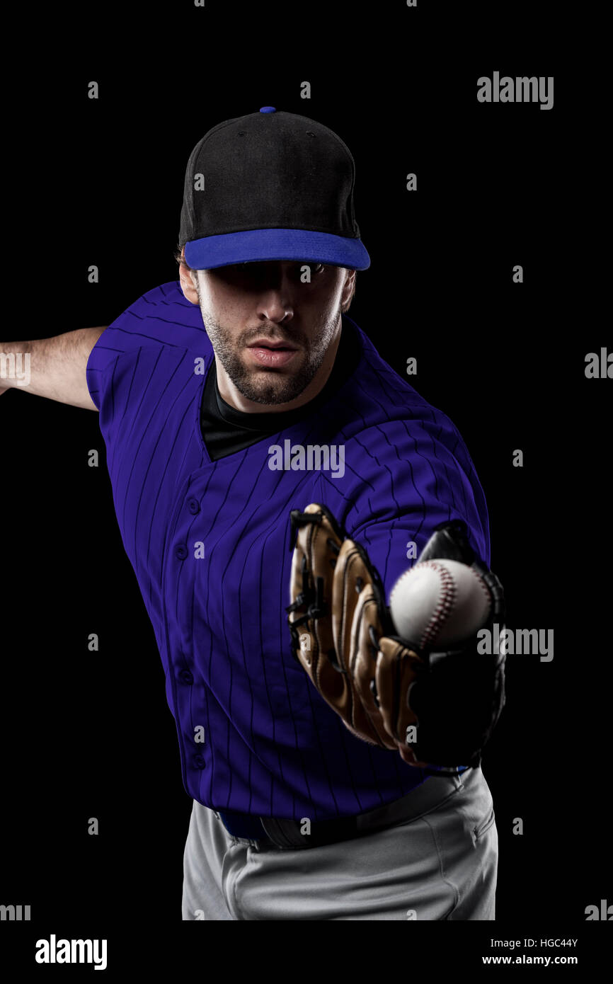 Baseball Player with a blue uniform on a black background Stock Photo ...