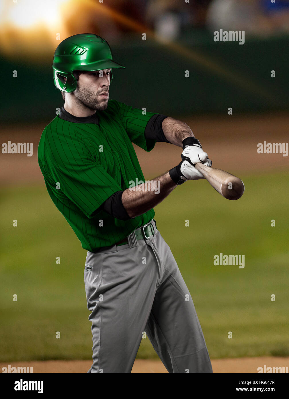 Baseball Player with a green uniform on baseball Stadium Stock Photo ...