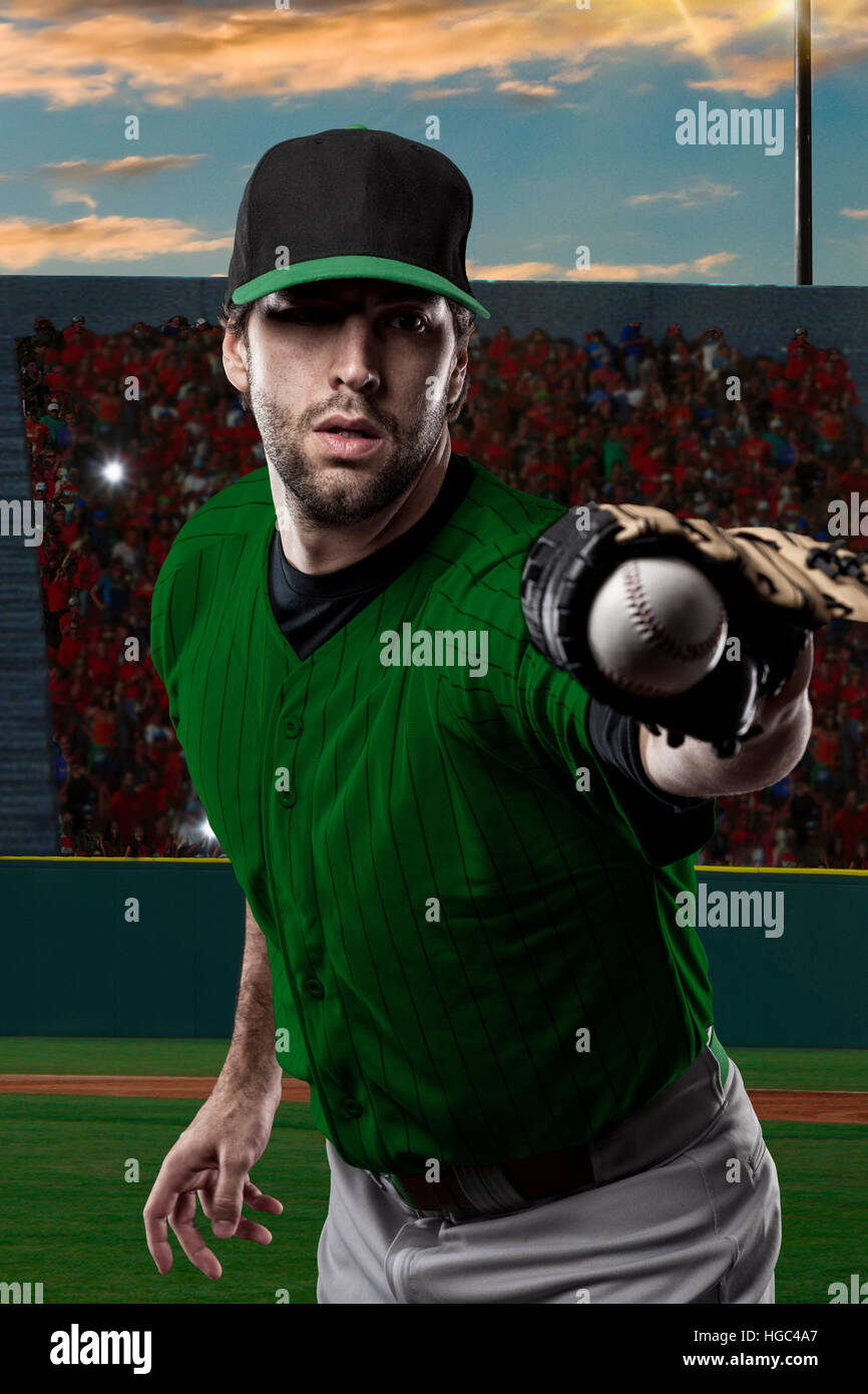 Baseball Player with a green uniform on baseball Stadium Stock Photo ...