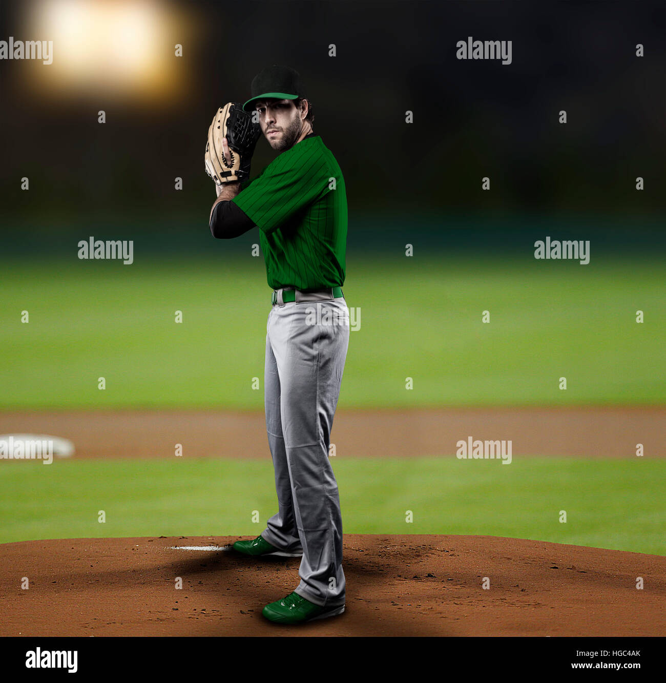 Pitcher Baseball Player with a green uniform on baseball Stadium Stock ...