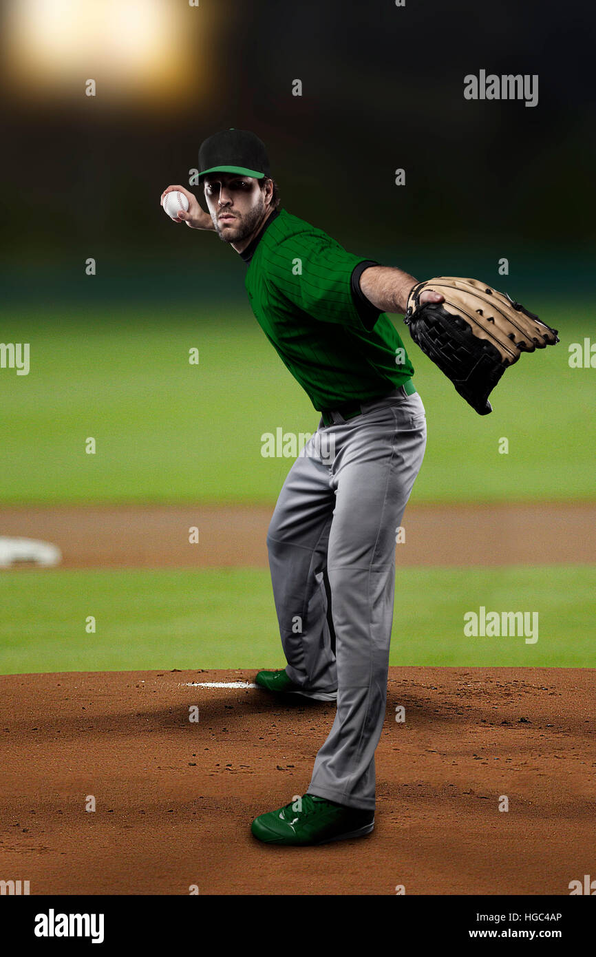 Pitcher Baseball Player with a green uniform on baseball Stadium Stock ...