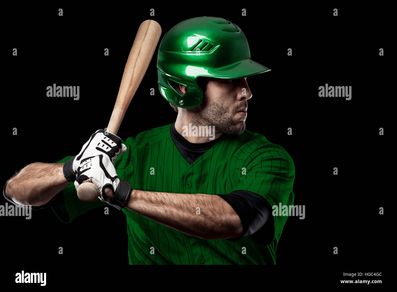 Baseball Player with a green uniform on a black background Stock Photo ...