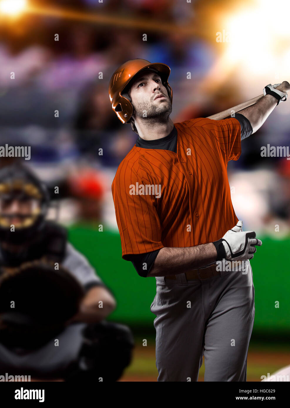 Baseball Player with a orange uniform on baseball Stadium Stock Photo ...