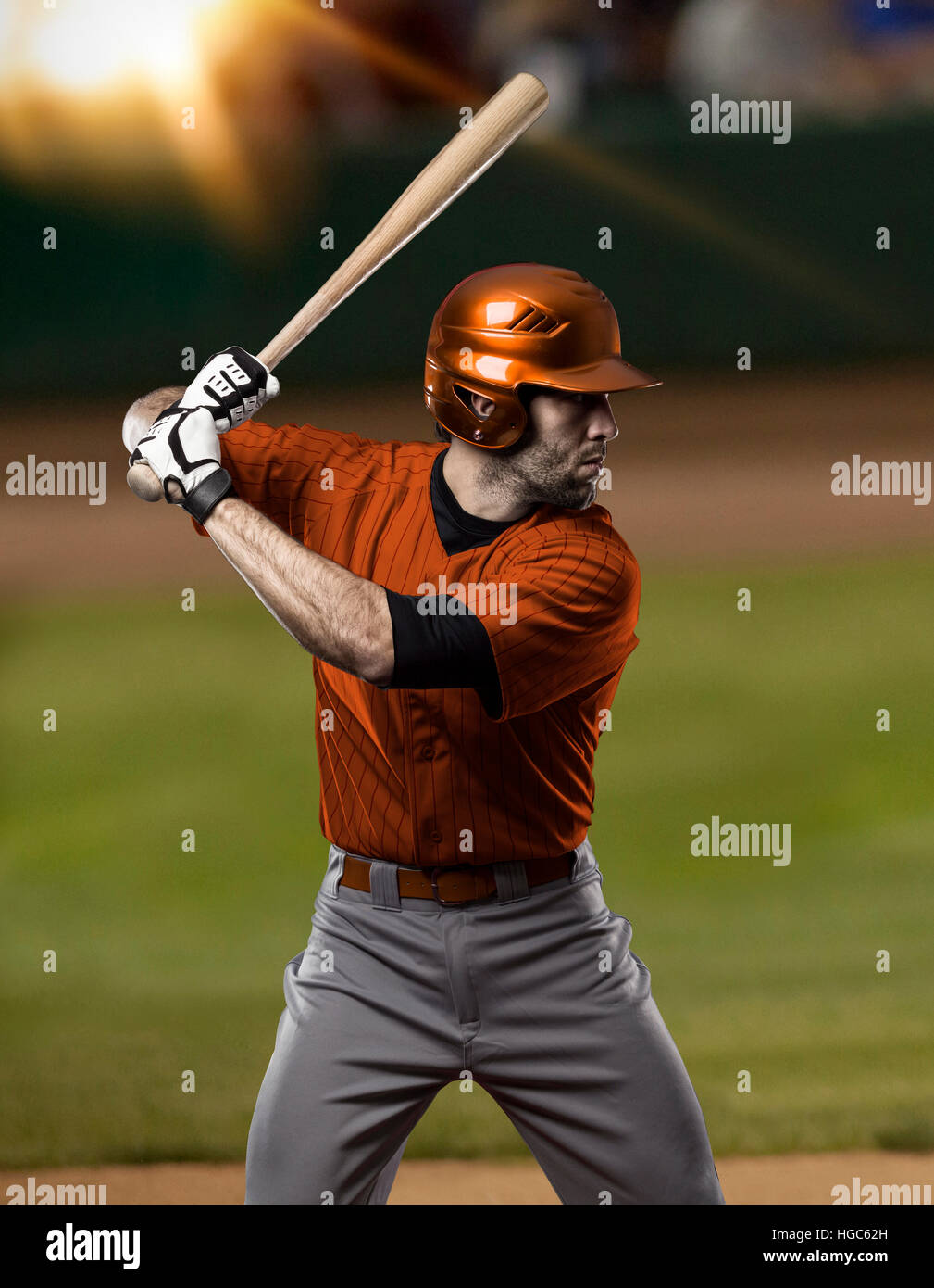 Baseball Player with a orange uniform on baseball Stadium Stock Photo ...