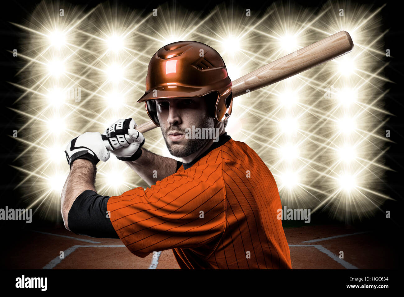 Baseball Player with a orange uniform in front of lights Stock Photo ...