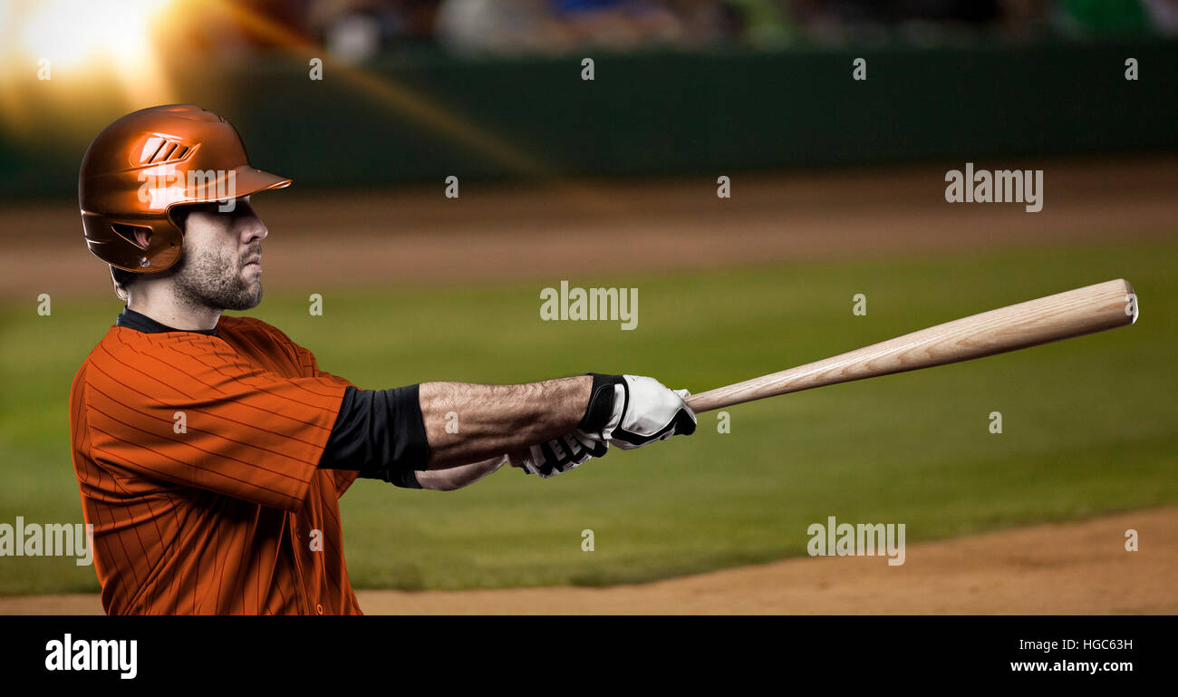 Baseball Player with a orange uniform on baseball Stadium Stock Photo ...