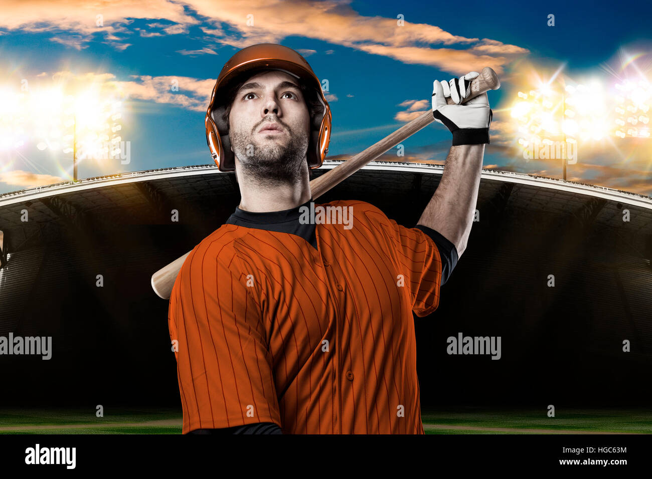 Baseball Player with a orange uniform on baseball Stadium Stock Photo ...
