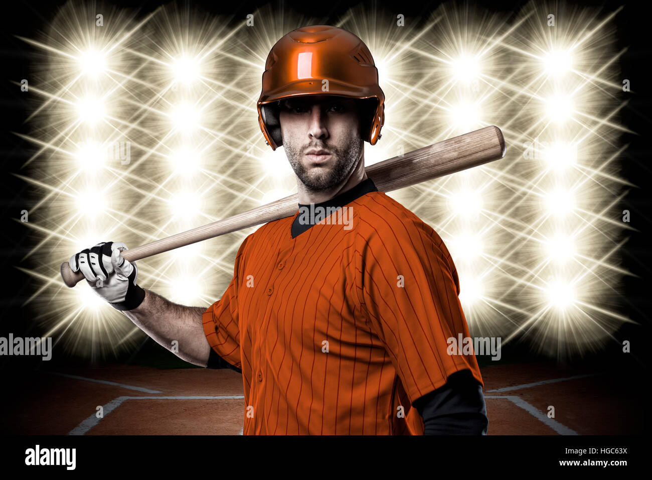 Baseball Player with a orange uniform in front of lights Stock Photo ...