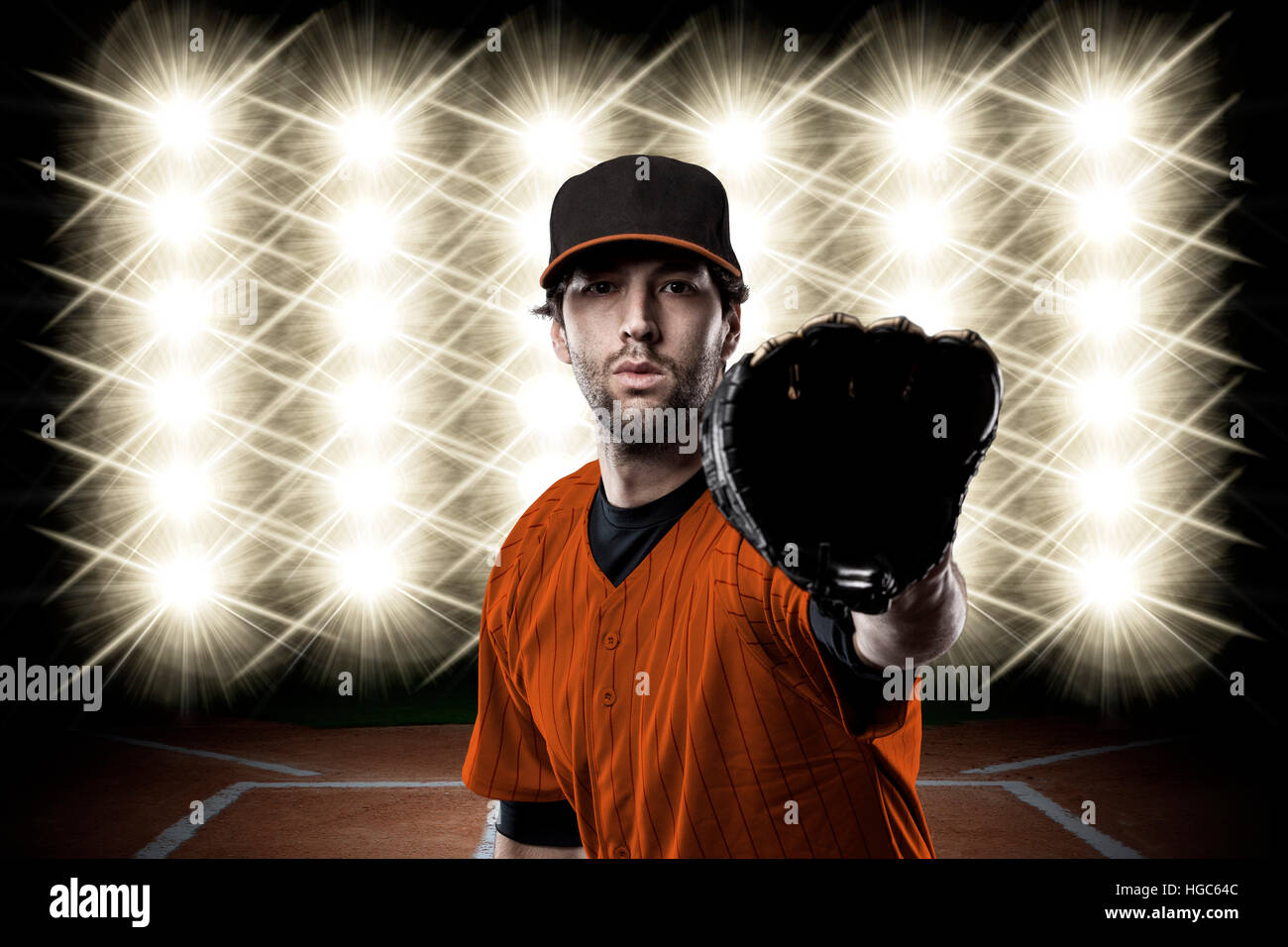 Baseball Player with a orange uniform in front of lights Stock Photo ...