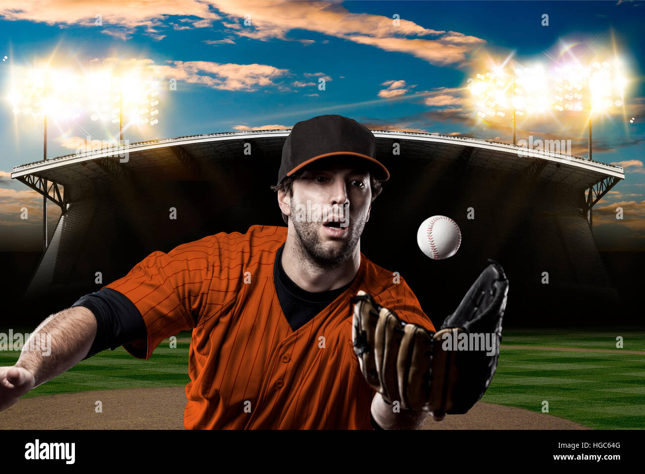 Baseball Player with a orange uniform on baseball Stadium Stock Photo ...