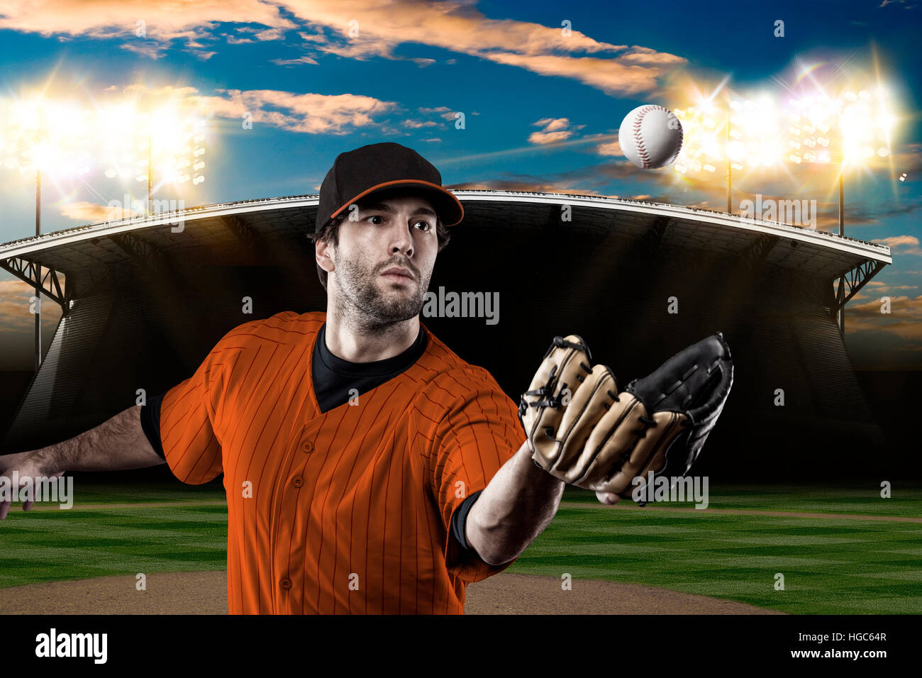 Baseball Player with a orange uniform on baseball Stadium Stock Photo ...