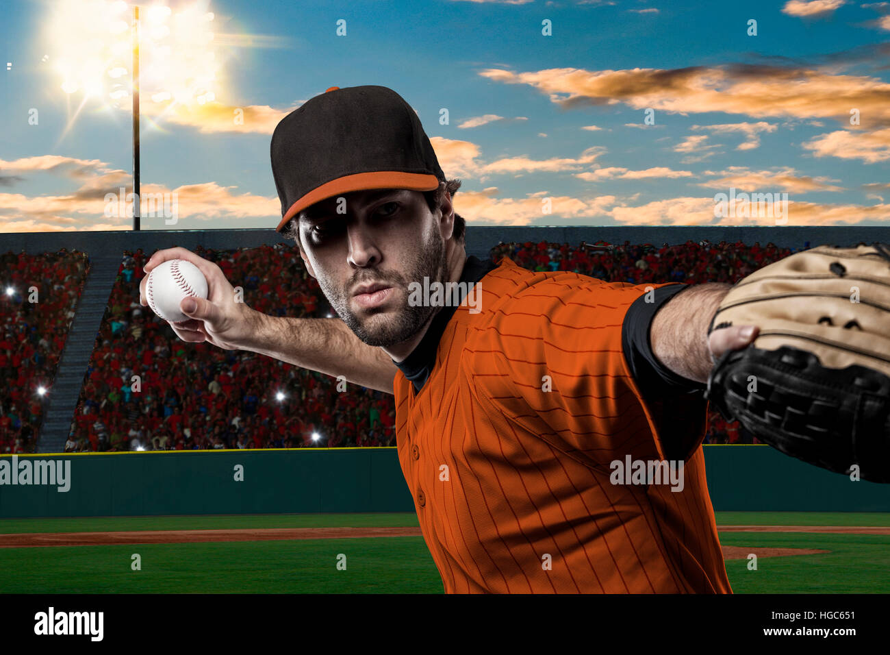 Baseball Player with a orange uniform on baseball Stadium Stock Photo ...