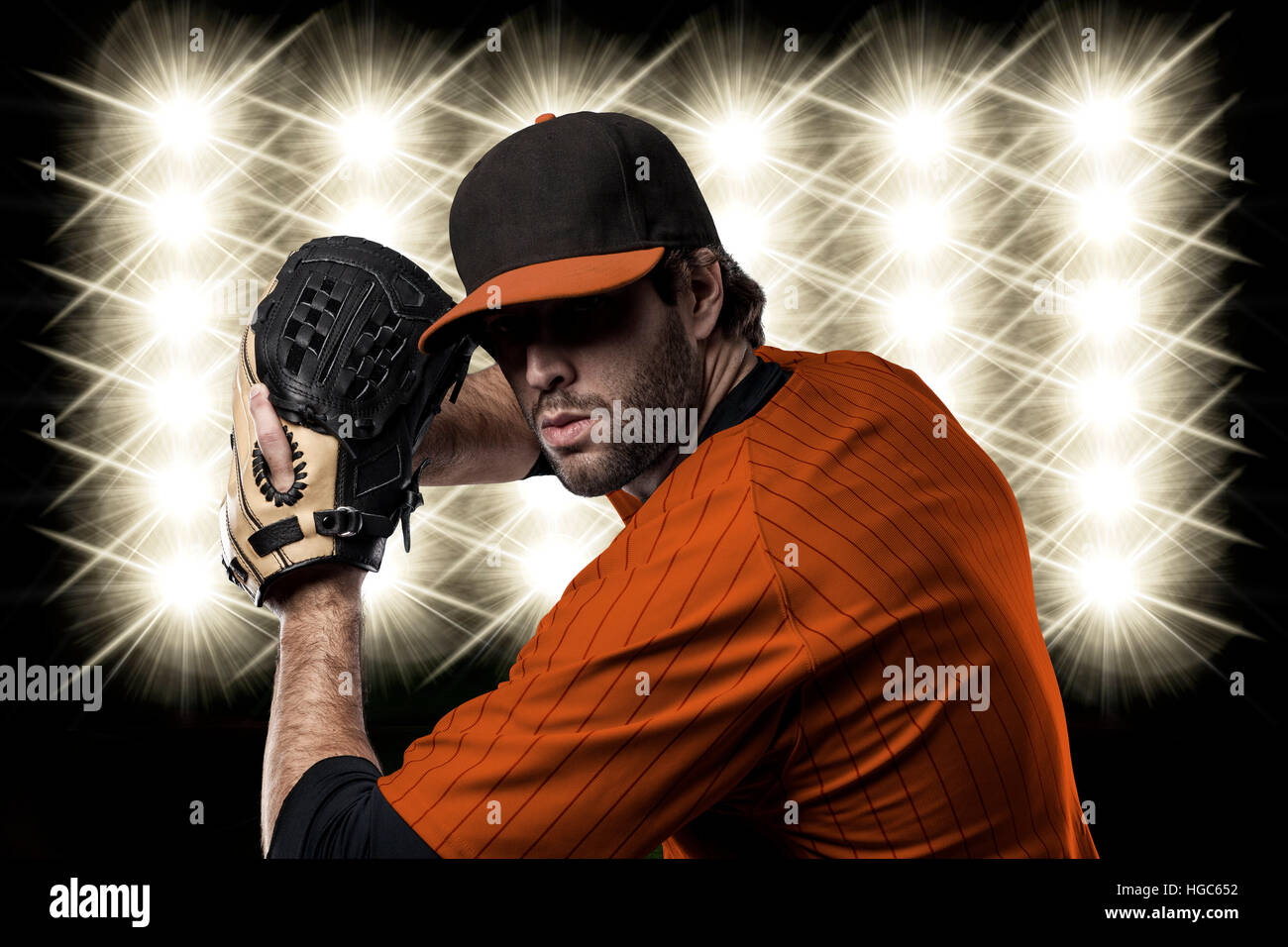 Baseball Player with a orange uniform in front of lights Stock Photo ...