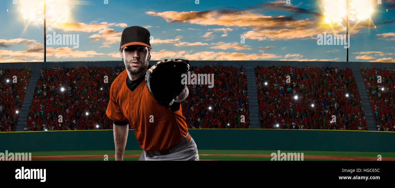 Baseball Player with a orange uniform on baseball Stadium Stock Photo ...