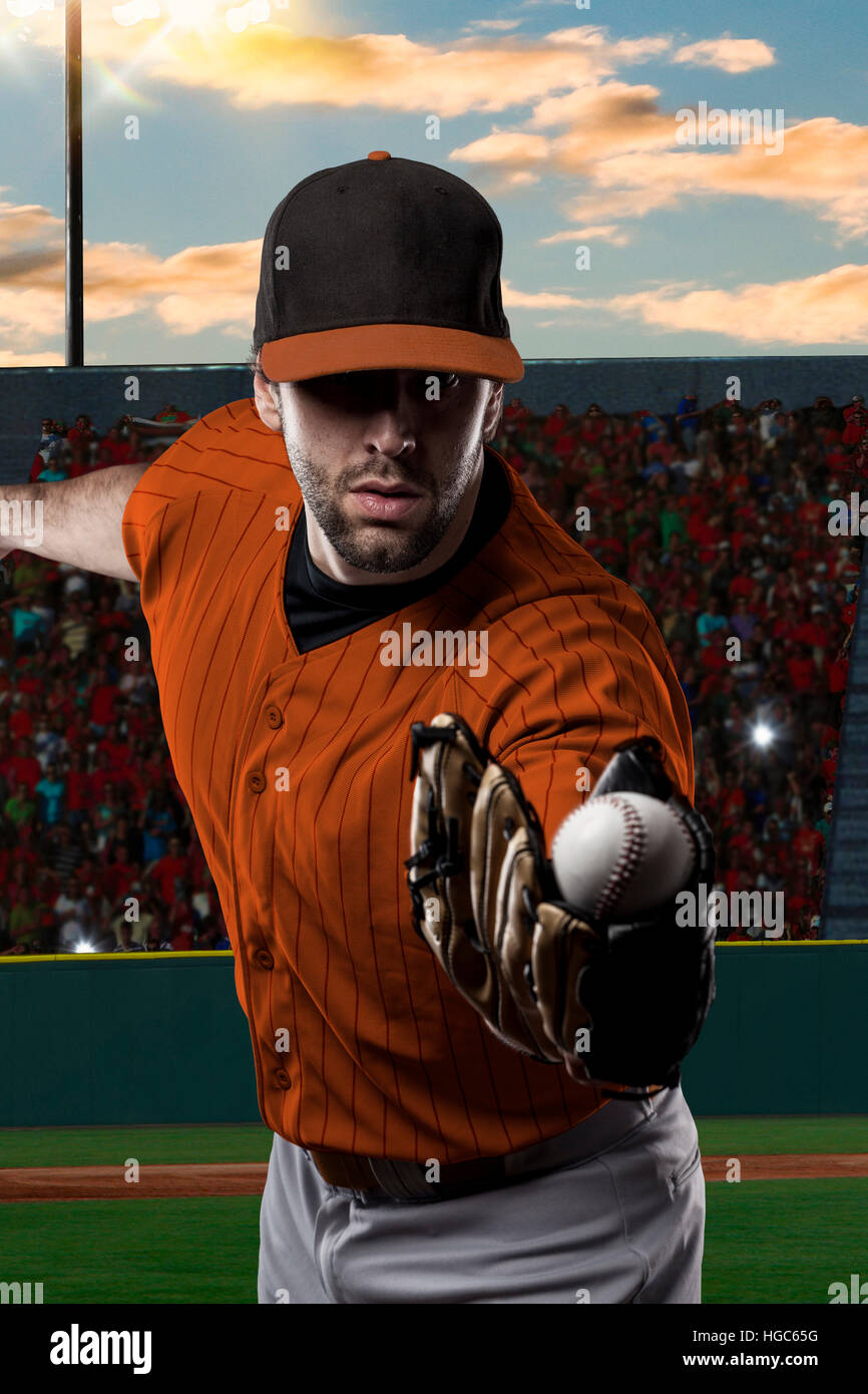 Baseball Player with a orange uniform on baseball Stadium Stock Photo ...