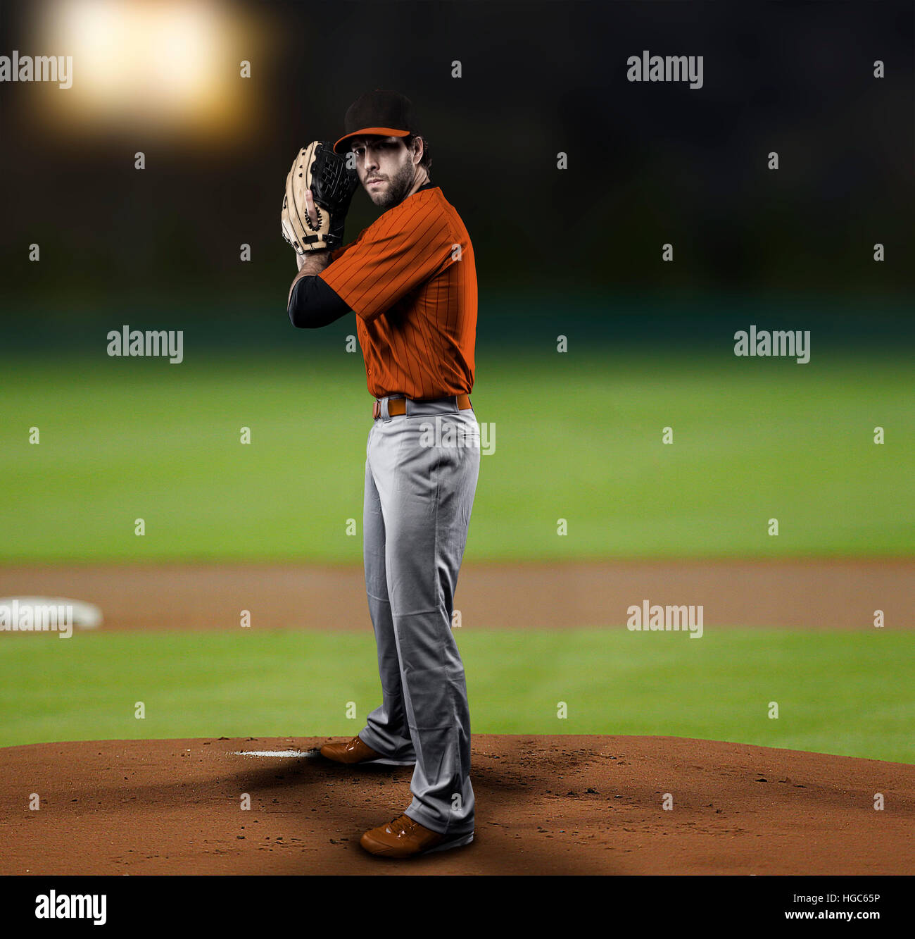 Pitcher Baseball Player with a orange uniform on baseball Stadium Stock ...