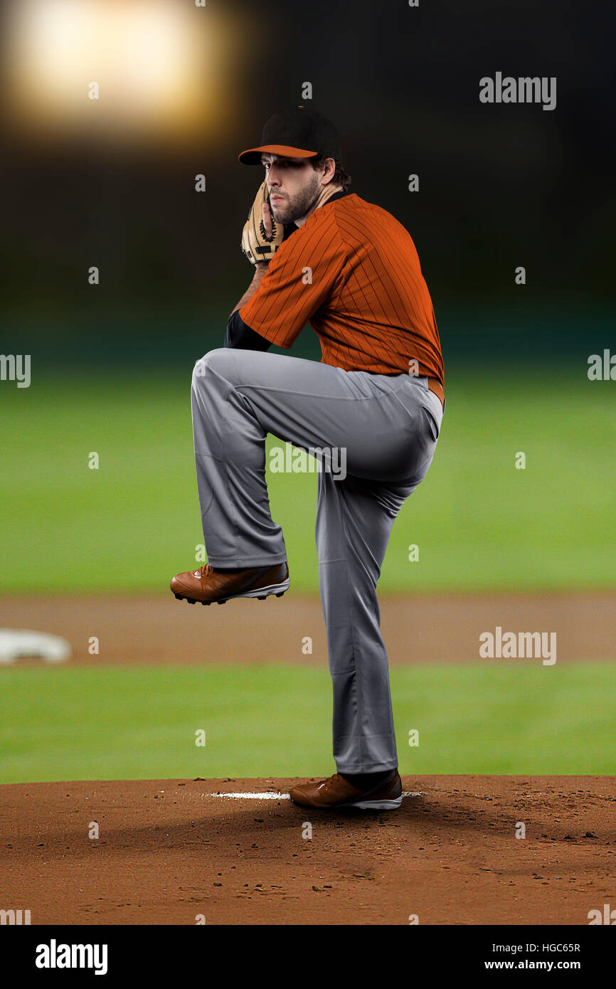 Pitcher Baseball Player with a orange uniform on baseball Stadium Stock ...