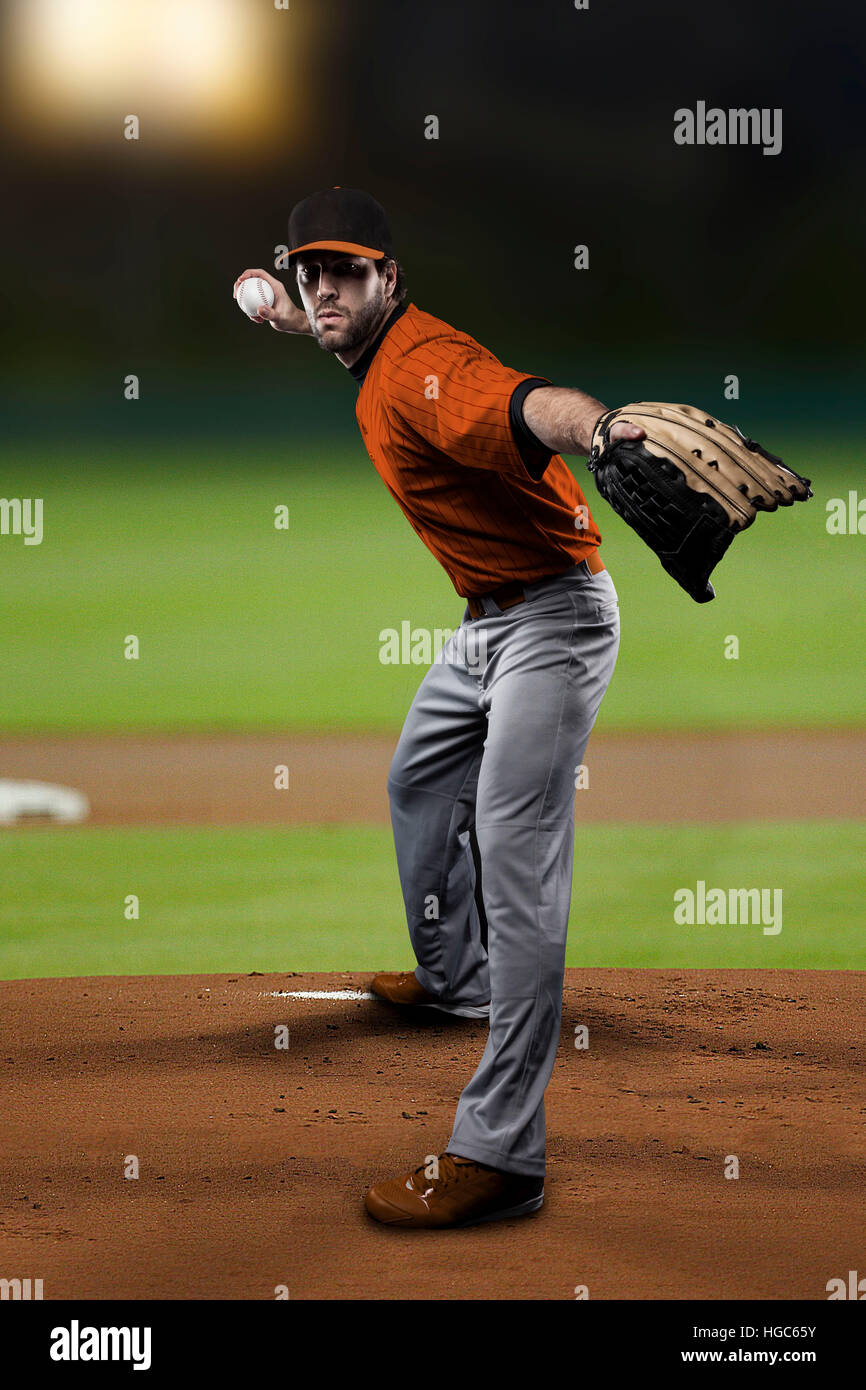 Pitcher Baseball Player with a orange uniform on baseball Stadium Stock ...