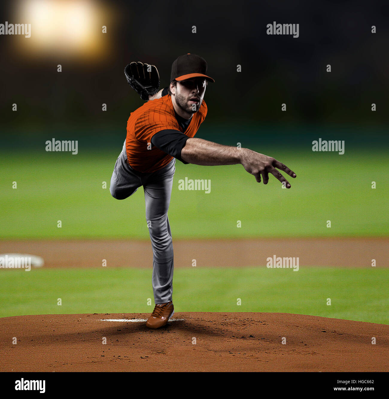 Pitcher Baseball Player with a orange uniform on baseball Stadium Stock ...