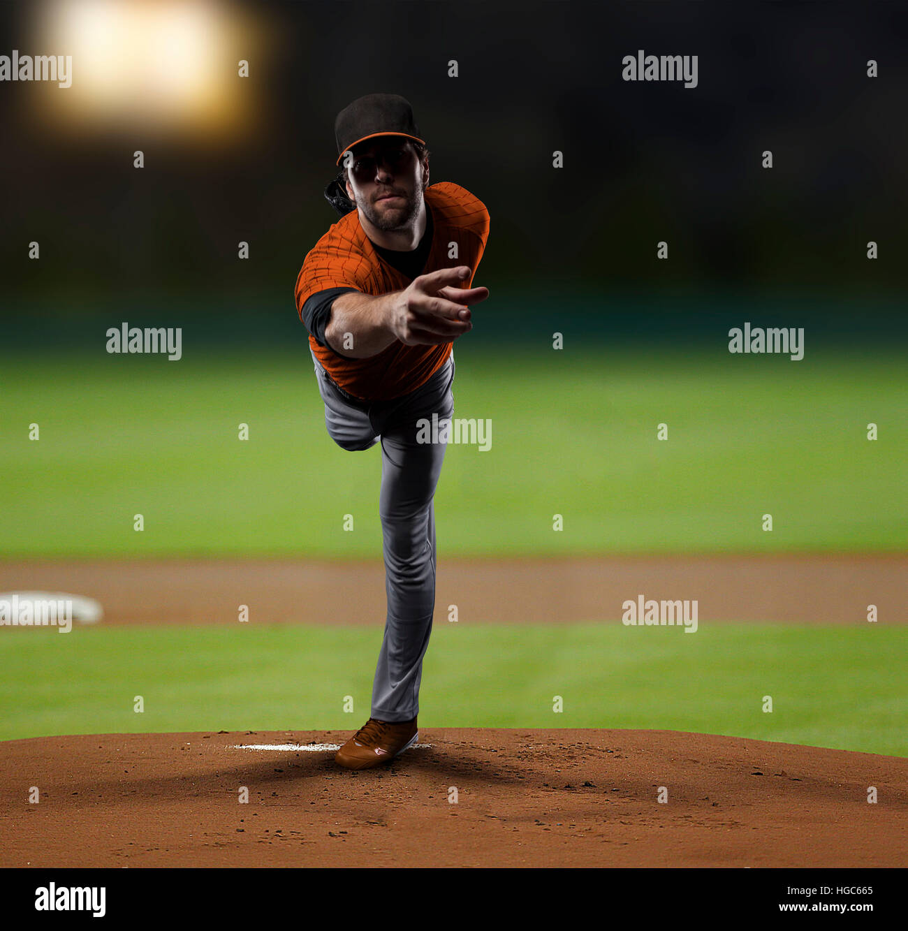 Pitcher Baseball Player with a orange uniform on baseball Stadium Stock ...