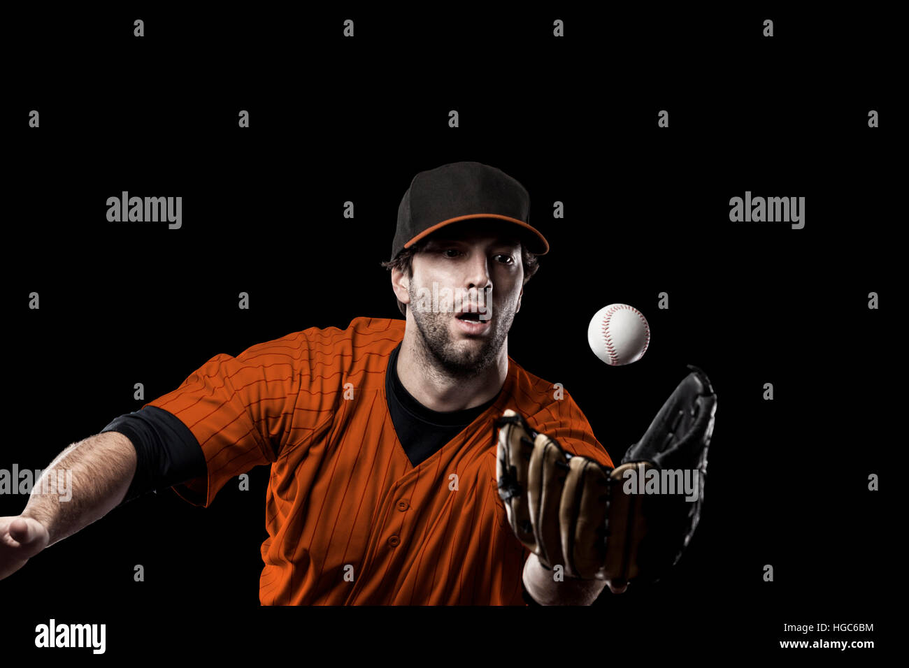 Baseball Player with a orange uniform on a black background Stock Photo ...