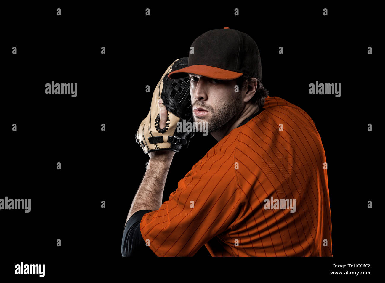 Pitcher Baseball Player with a orange uniform on a black background ...