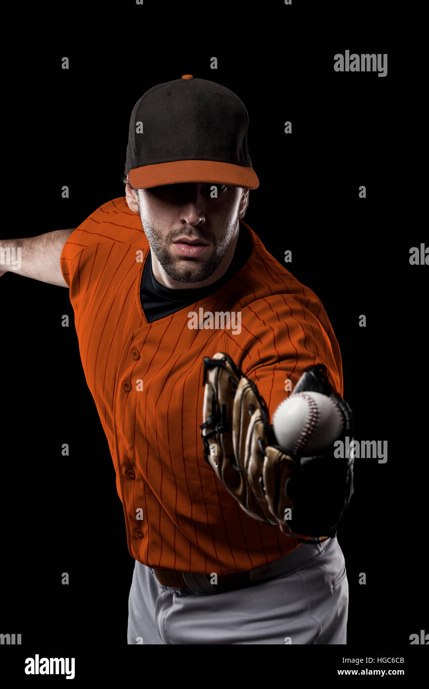 Baseball Player with a orange uniform on a black background Stock Photo ...