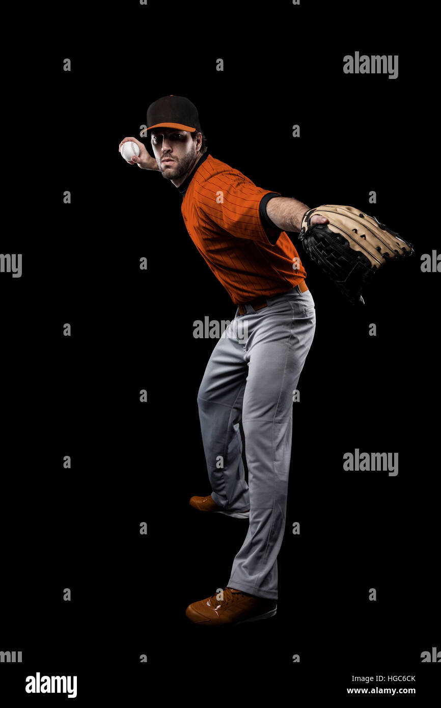 Pitcher Baseball Player with a orange uniform on a black background ...