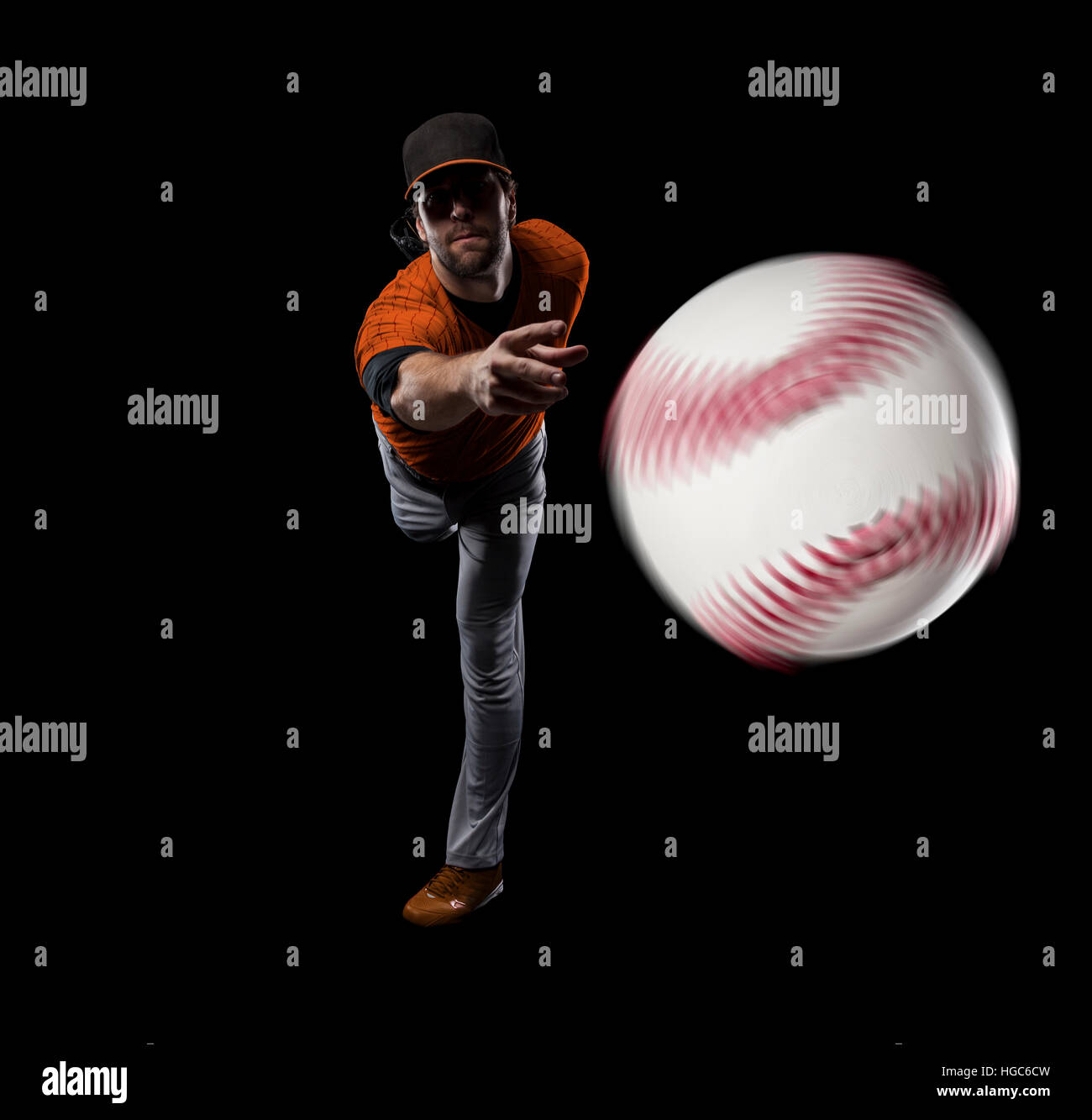Pitcher Baseball Player with a orange uniform on a black background ...