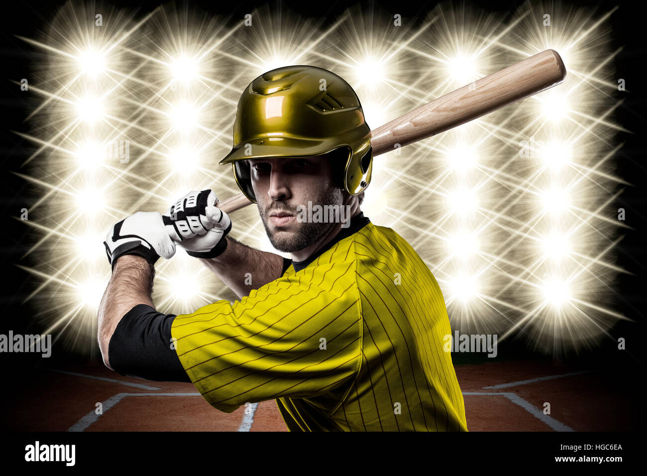 Baseball Player with a yellow uniform in front of lights Stock Photo ...