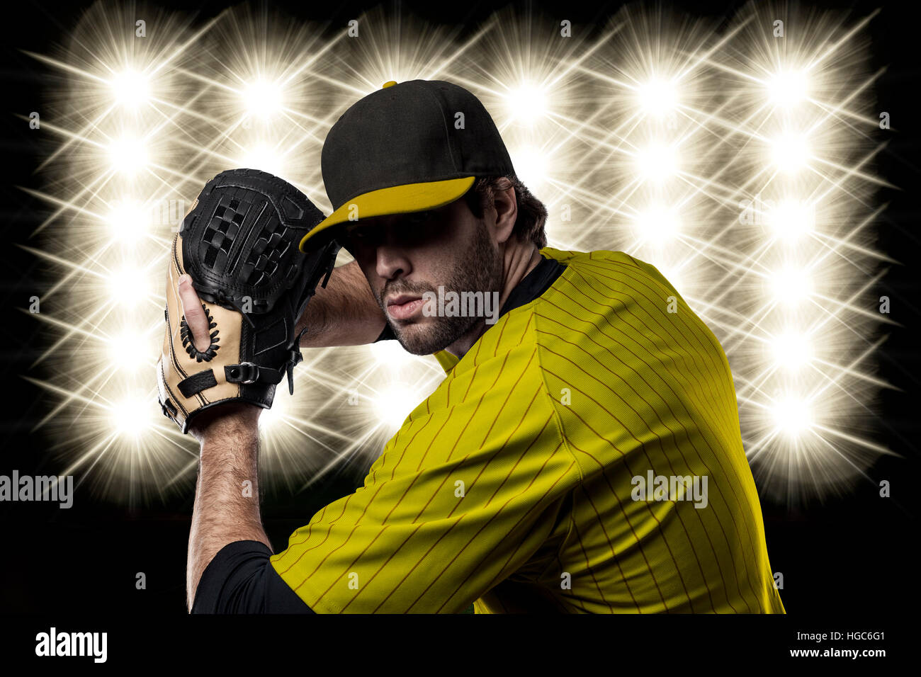 Baseball Player with a yellow uniform in front of lights Stock Photo ...