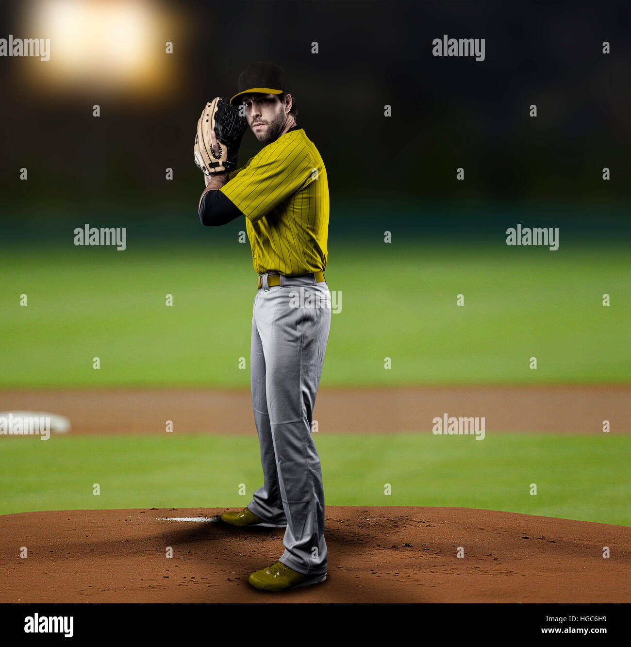 Pitcher Baseball Player with a yellow uniform on baseball Stadium Stock ...