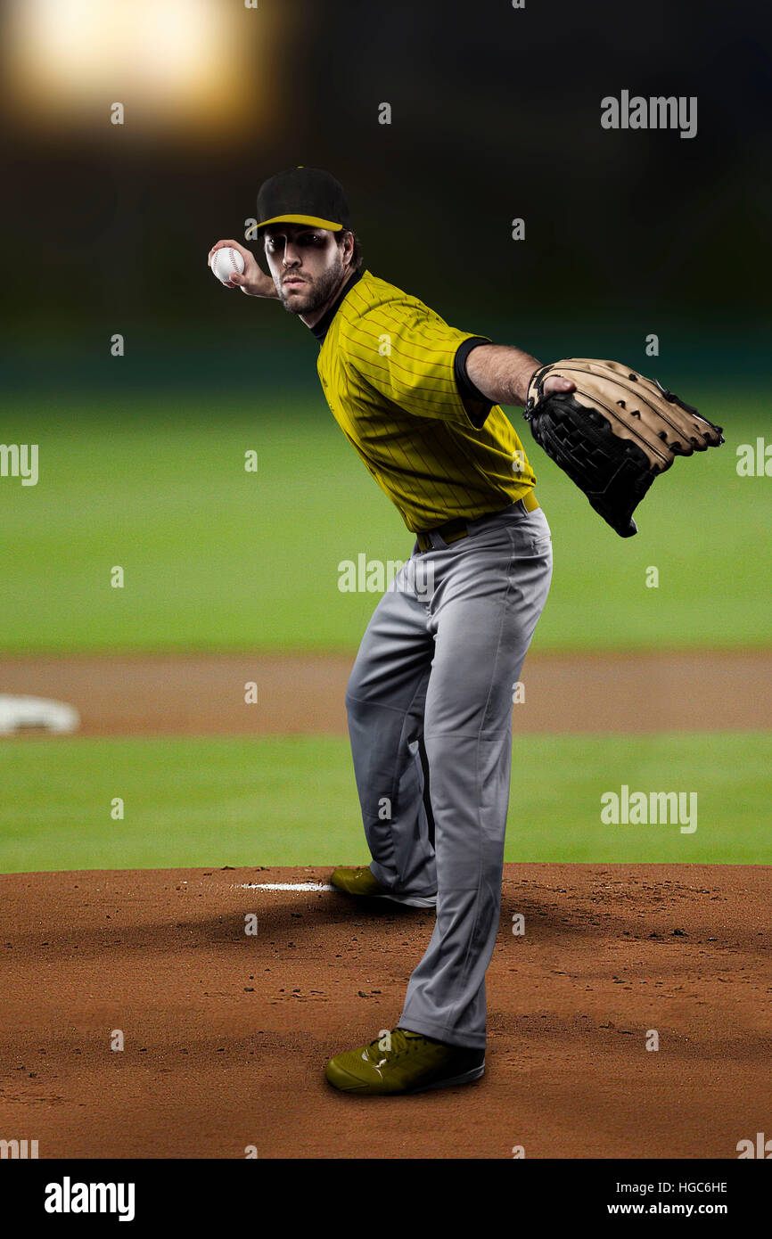 Pitcher Baseball Player with a yellow uniform on baseball Stadium Stock ...