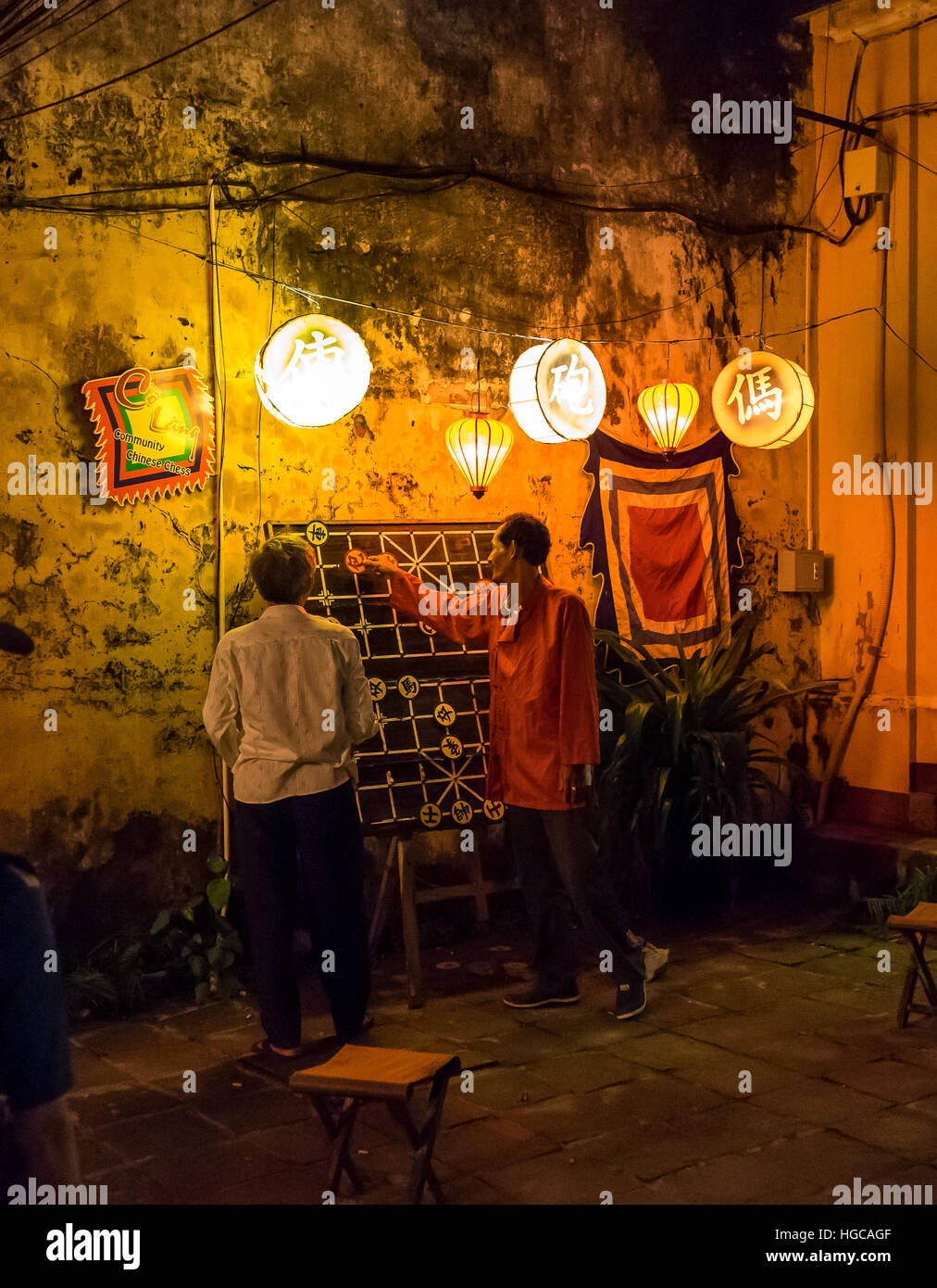 Two men playing a large size chinese chess game at night, in the ...