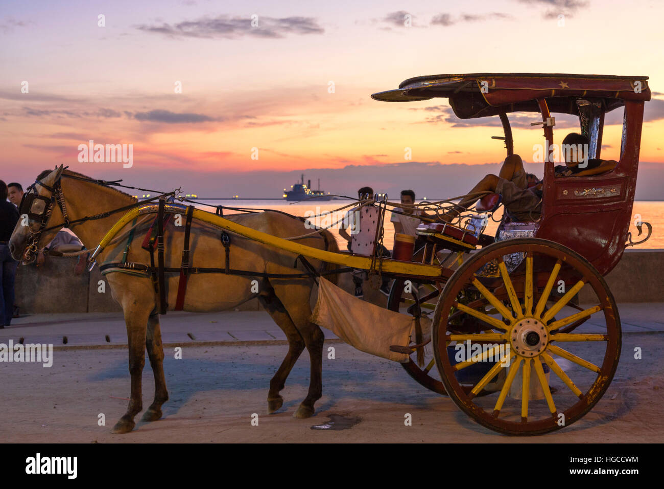 Kalesa on Roxas Boulevarde at sunset, Manila, Philippines Stock Photo ...