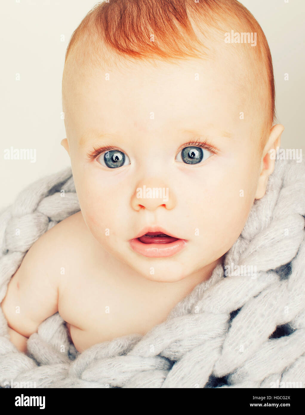 little cute red head baby in scarf all over him close up isolate Stock ...