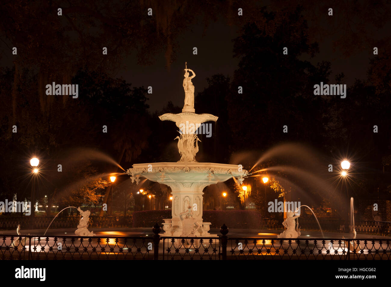 Forsyth Fountain is surrounded by lights and tall trees at night in ...