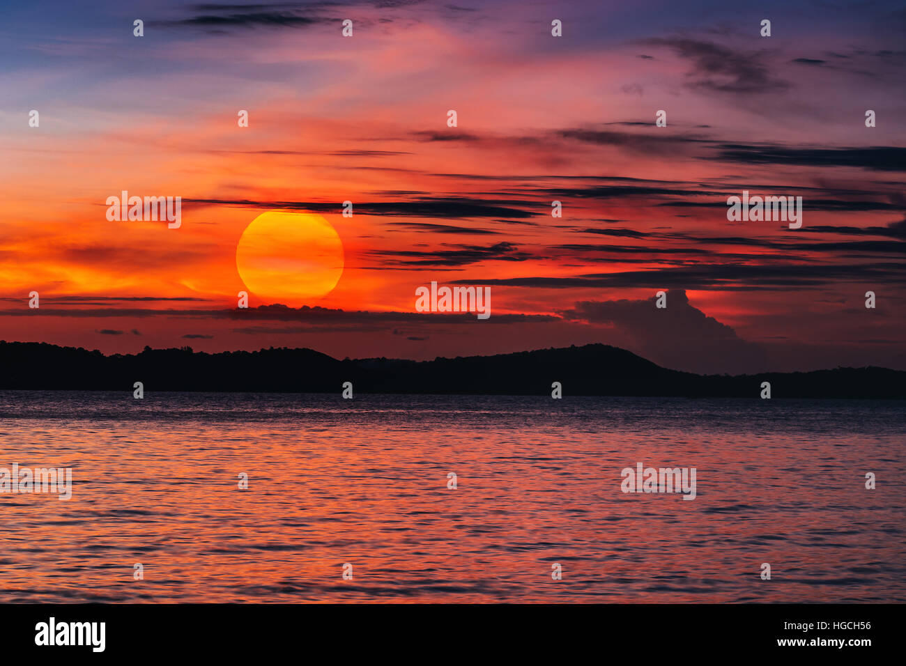 Beautiful big sunset over the mountain on sea Stock Photo - Alamy