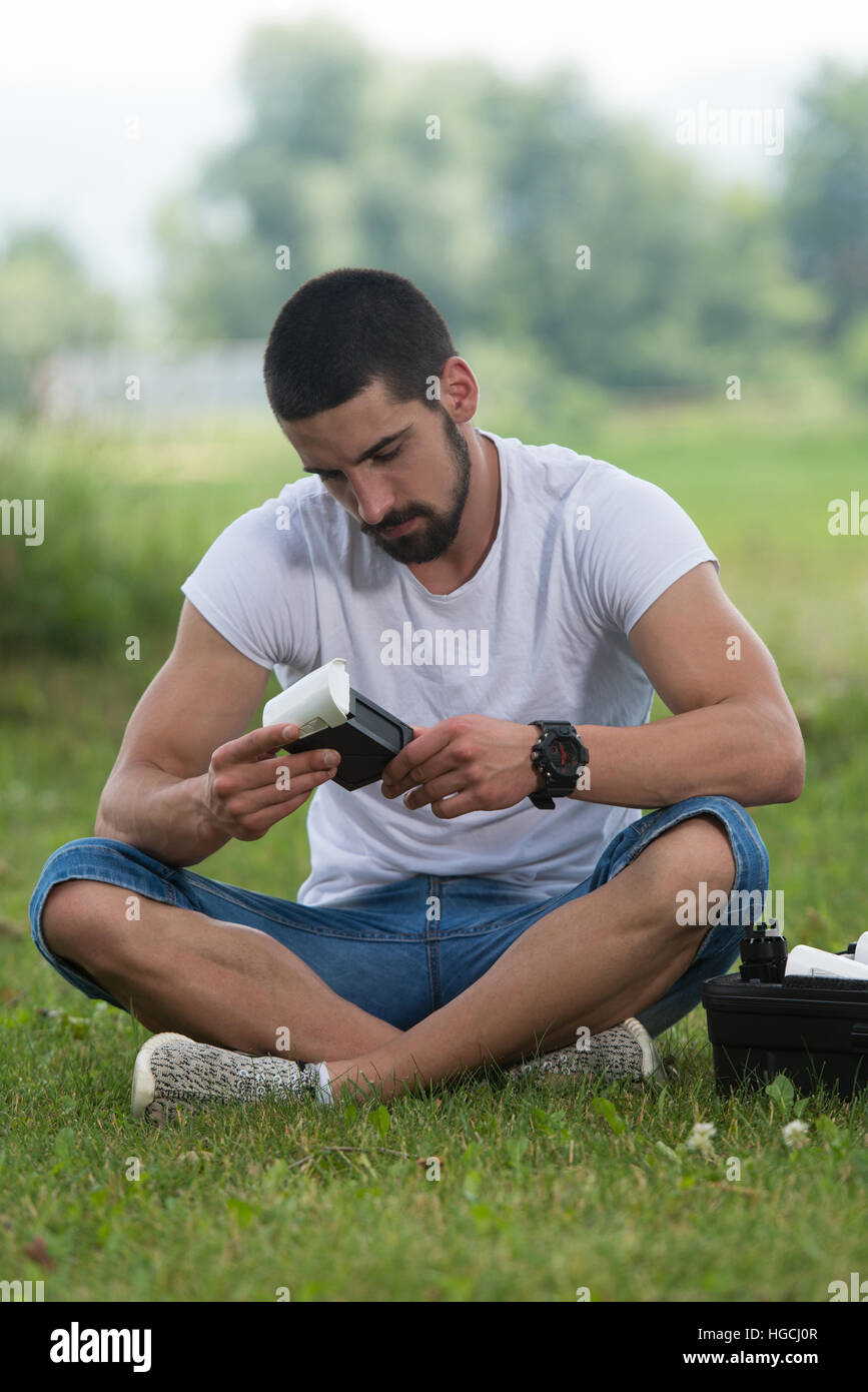 Closeup of Young Engineer Man Checking the Battery of Uav Drone With ...