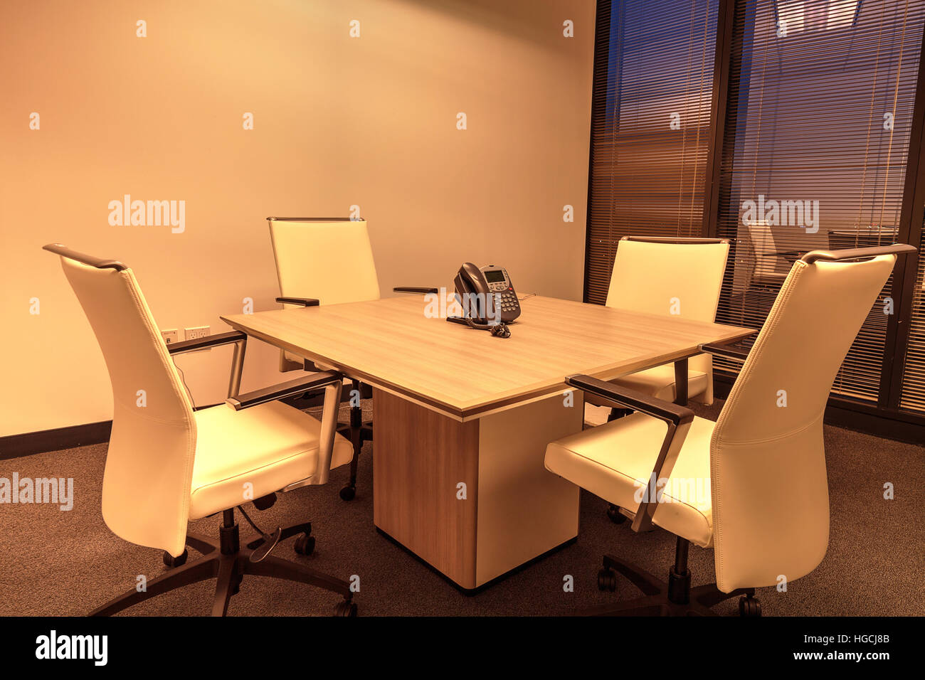 Small corporate conference room with a table and four chairs around a ...