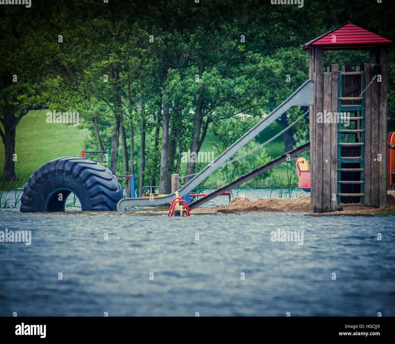 Floodwaters on kids playground Stock Photo - Alamy