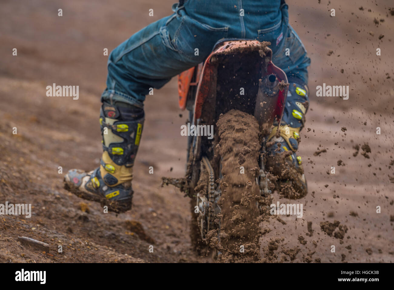 Biker accelerating with lots of mud Stock Photo - Alamy
